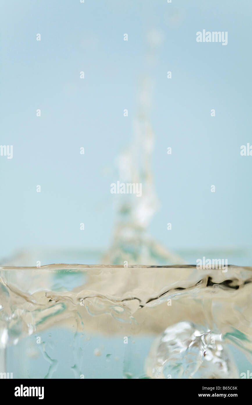 Water splashing from ice-cube dropped into glass of water, extreme close-up Stock Photo - Alamy
