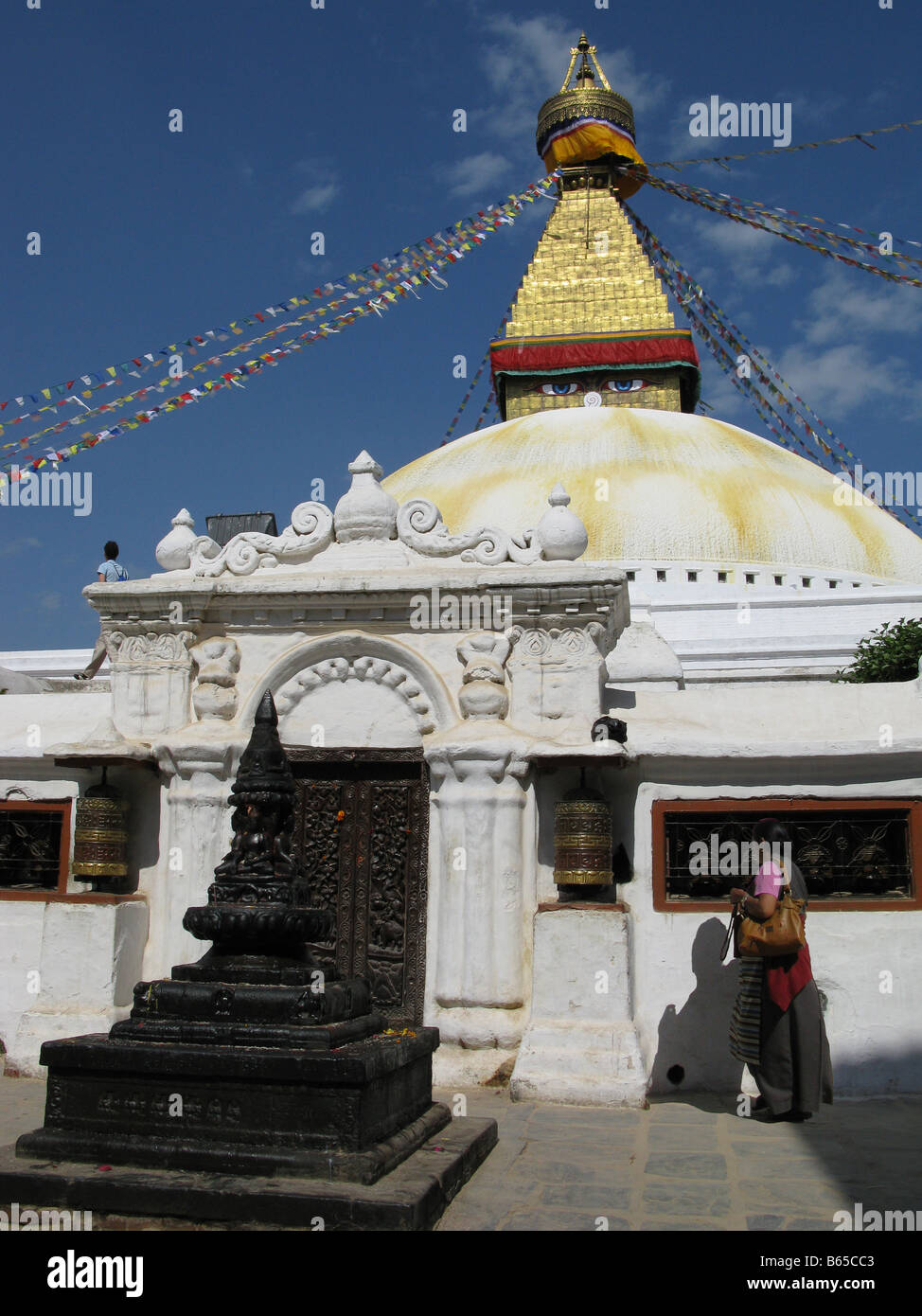 Stupa at Bouddhanath (see note in description) with woman turning ...