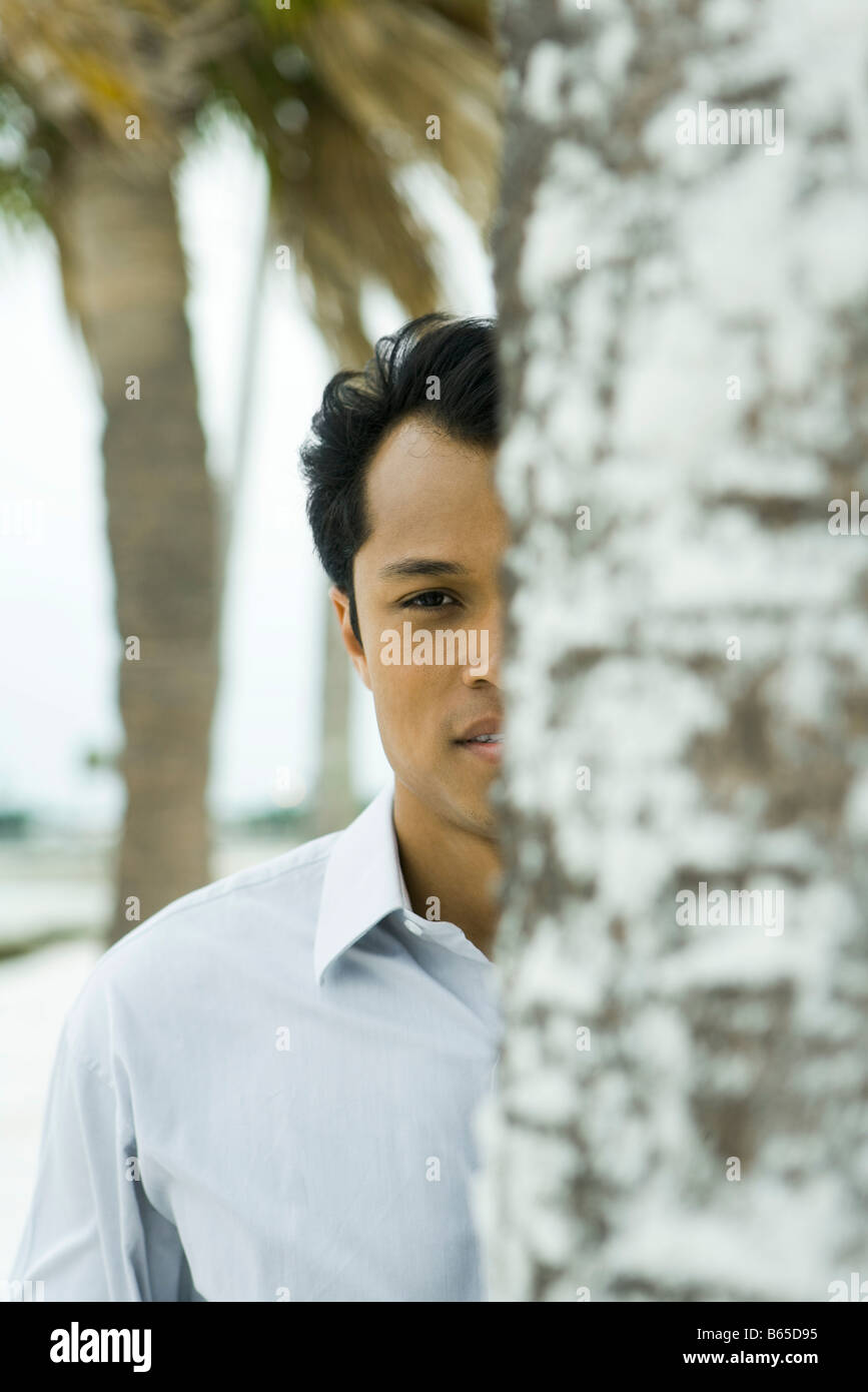 Man hiding behind tree from hi-res stock photography and images - Alamy