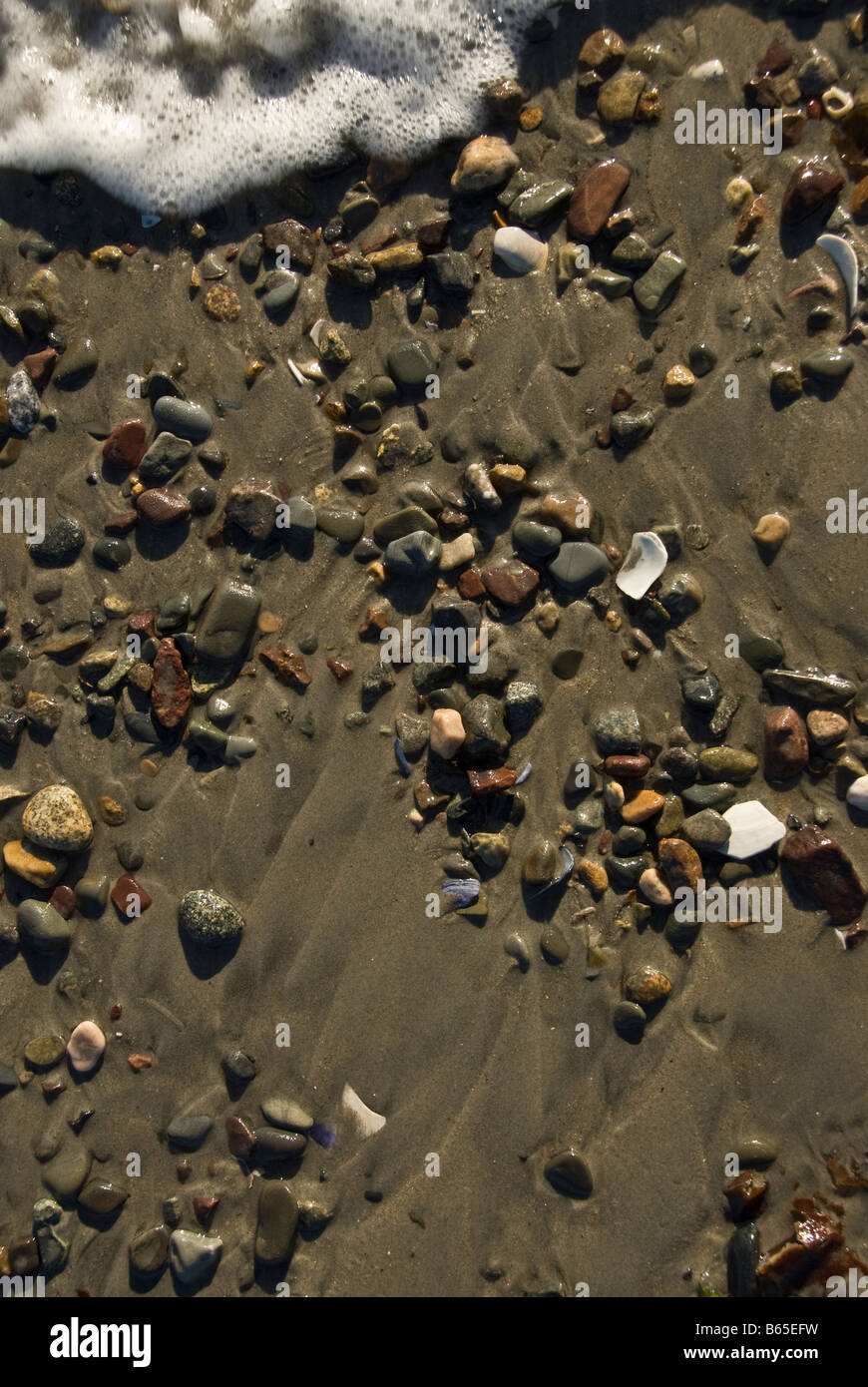 sandy beach and rocks with wave Stock Photo - Alamy