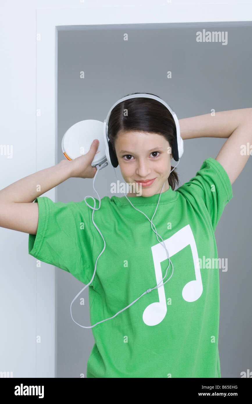 Girl listening to portable CD player, wearing tee-shirt with musical ...