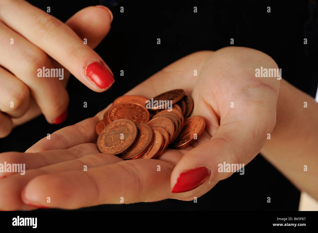 Counting one penny coins in the palm of a woman's hand. © Mark Shenley ...