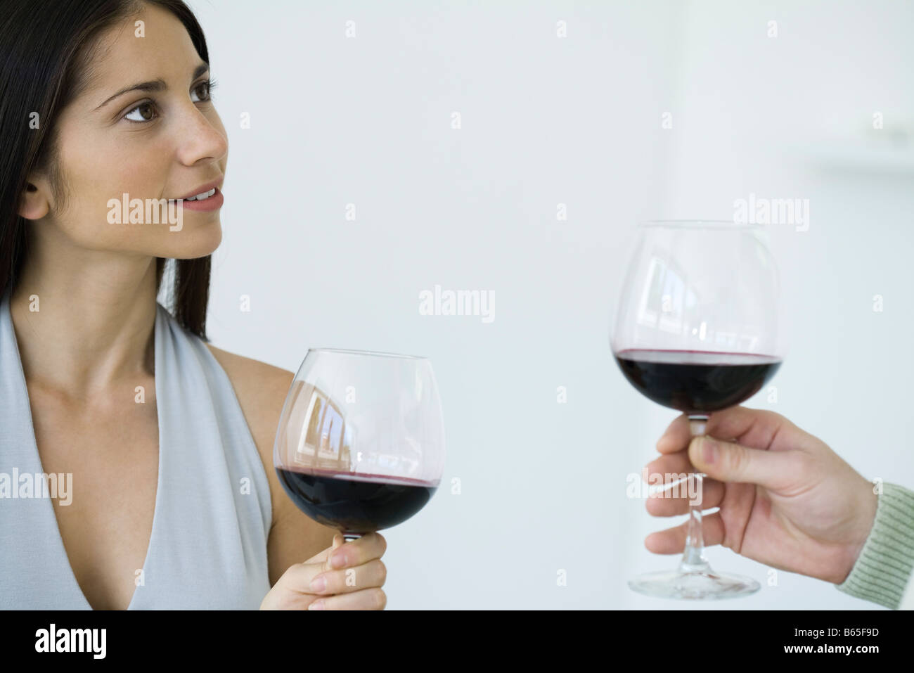 Couple holding glasses of red wine, cropped view Stock Photo - Alamy