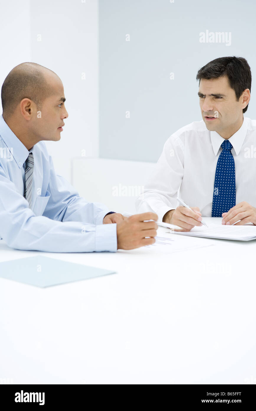 Two businessmen sitting at table having meeting Stock Photo - Alamy