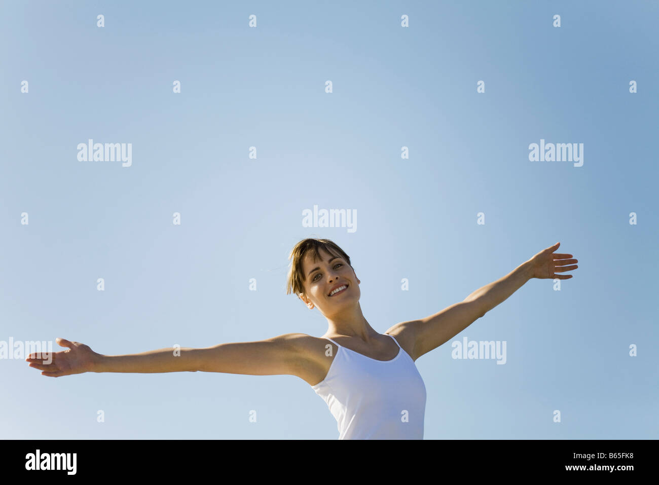 Woman standing outdoors with arms out, smiling at camera Stock Photo ...