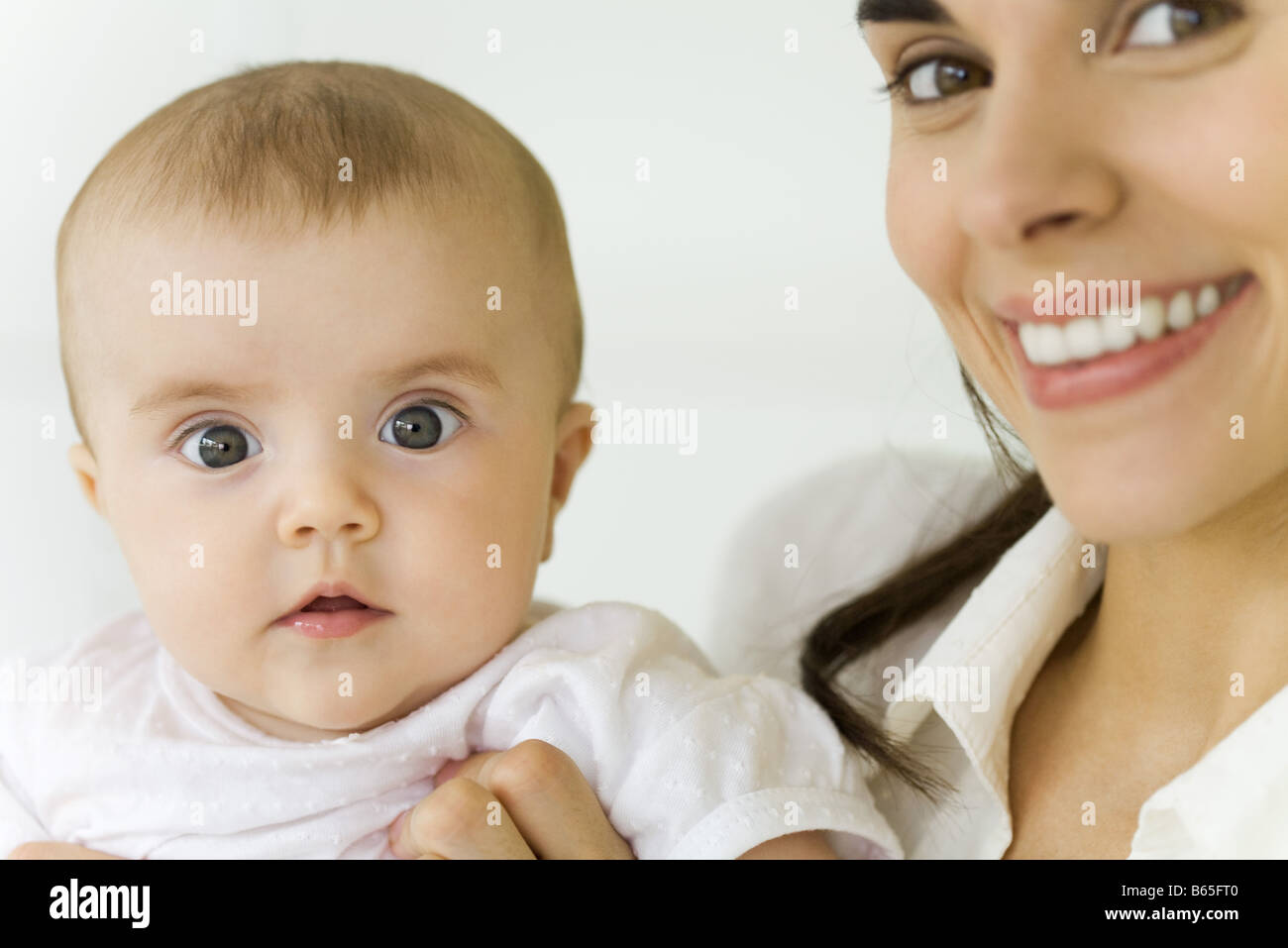 Mother holding baby, smiling at camera Stock Photo - Alamy
