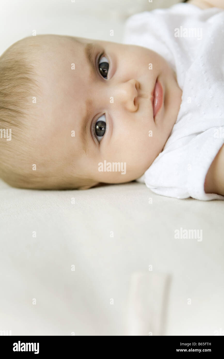 Baby lying on back, looking at camera, close-up Stock Photo - Alamy