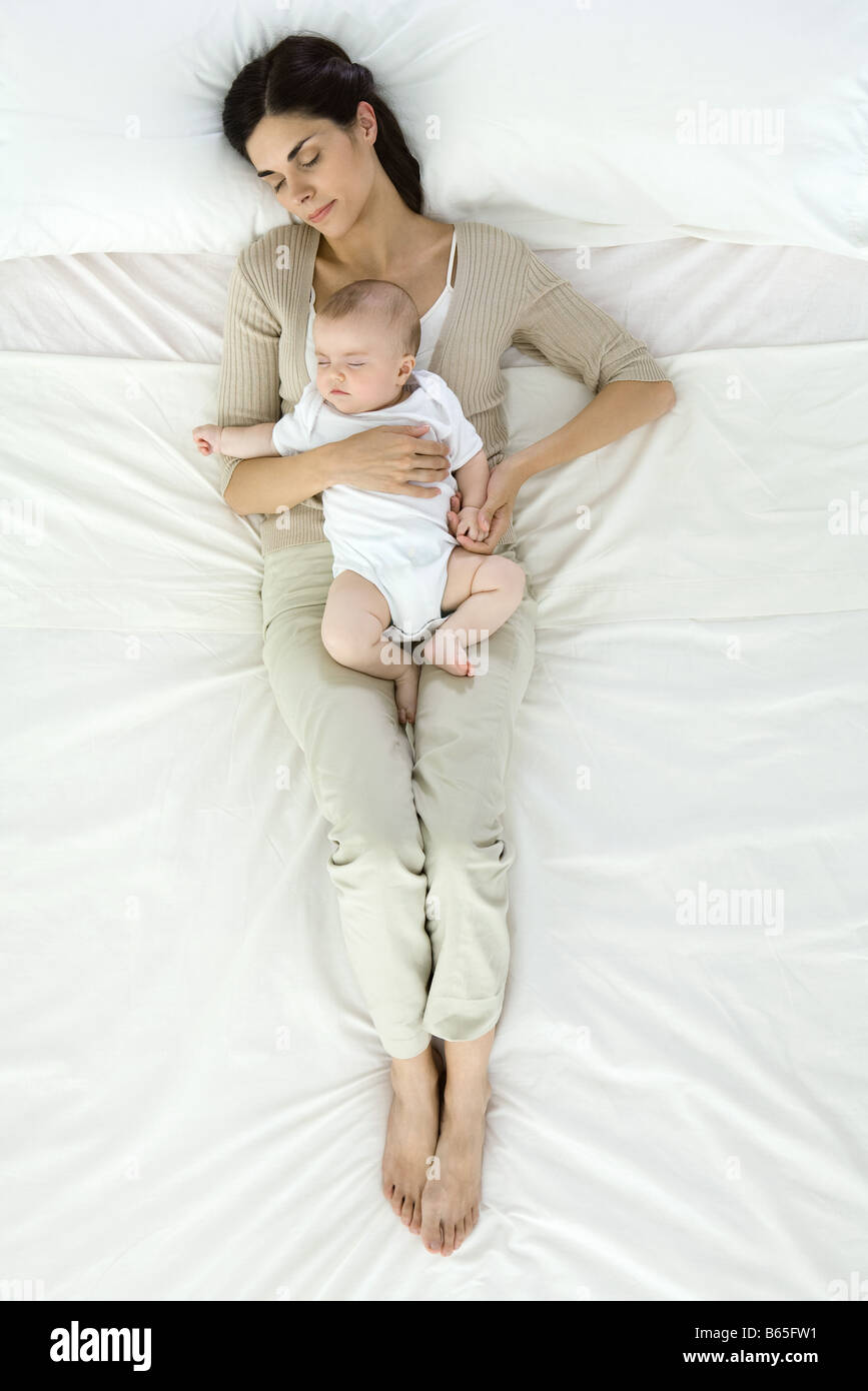 Mother and baby napping together on bed, overhead view Stock Photo - Alamy