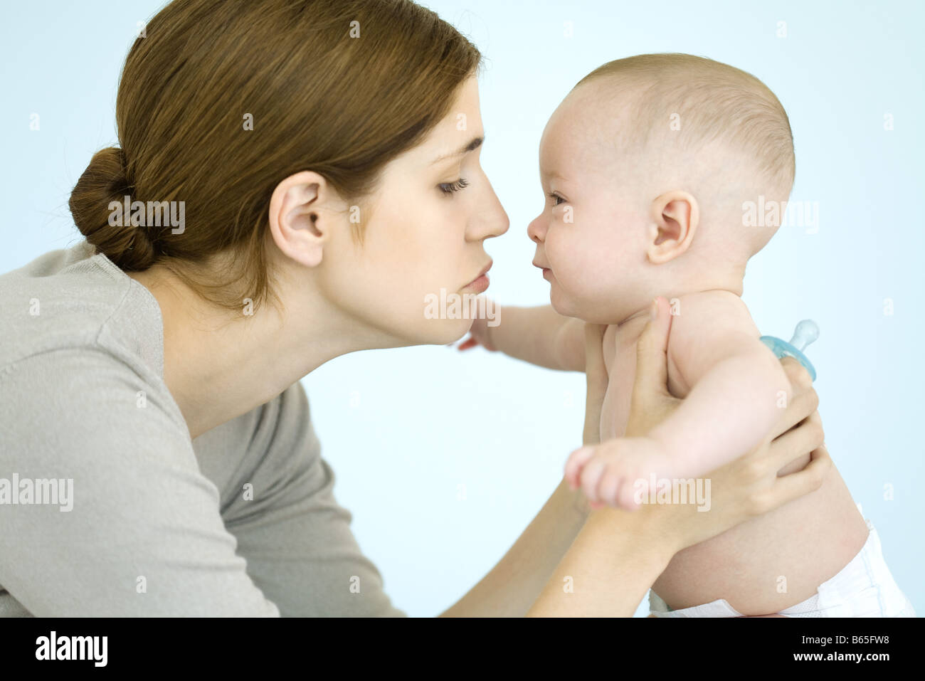 Mother holding baby up close to face, both smiling at each other Stock ...