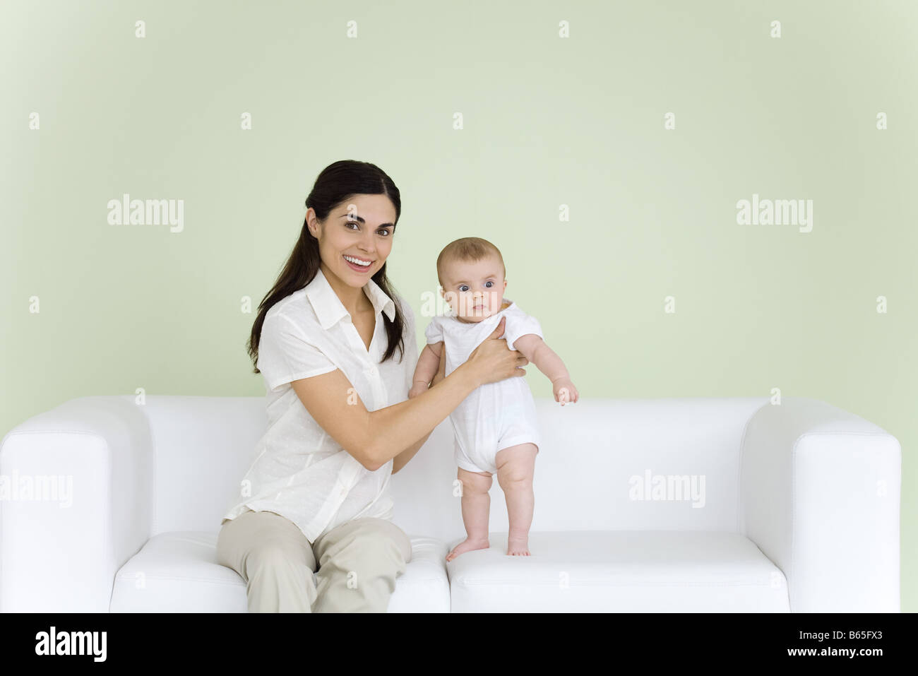 Mother helping baby stand hi-res stock photography and images - Alamy