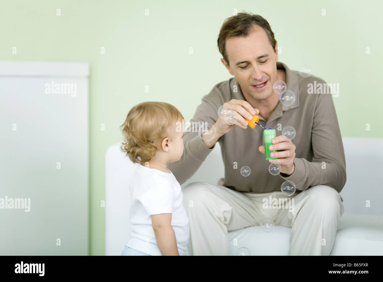 Father and toddler blowing bubbles together Stock Photo - Alamy
