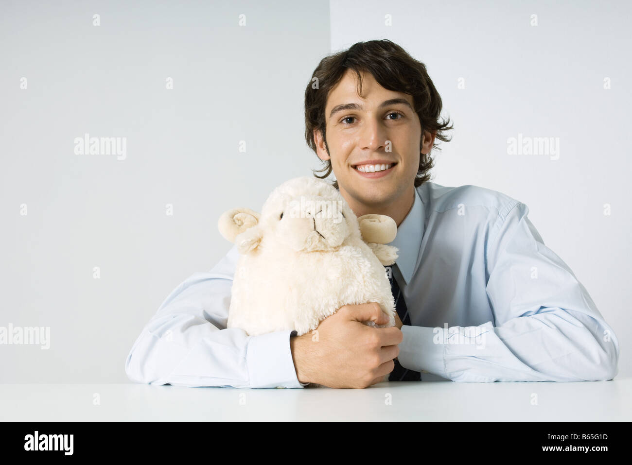 Young man hugging stuffed toy, smiling at camera Stock Photo - Alamy