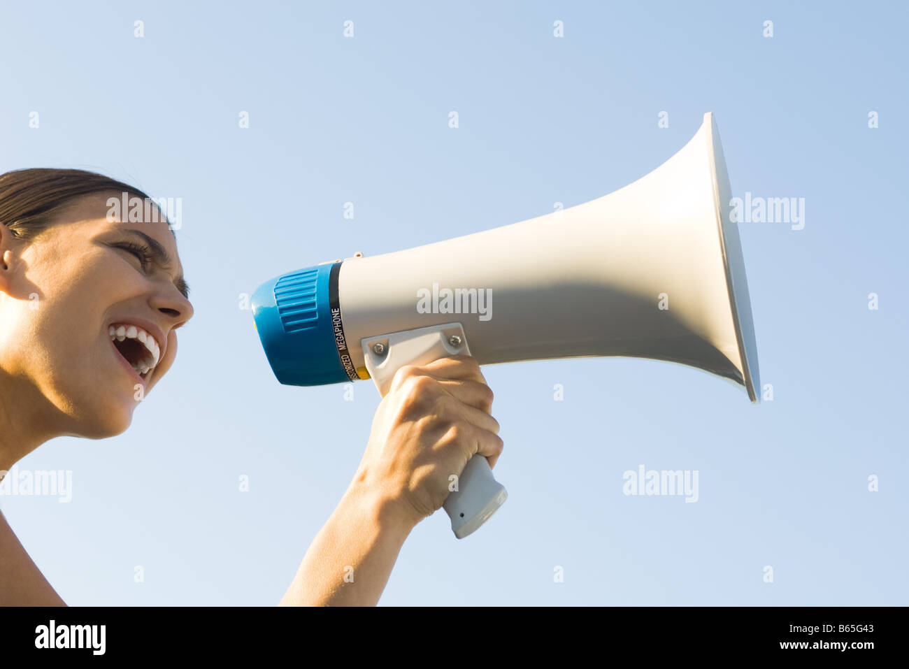 Woman shouting into megaphone, low angle view, cropped Stock Photo - Alamy