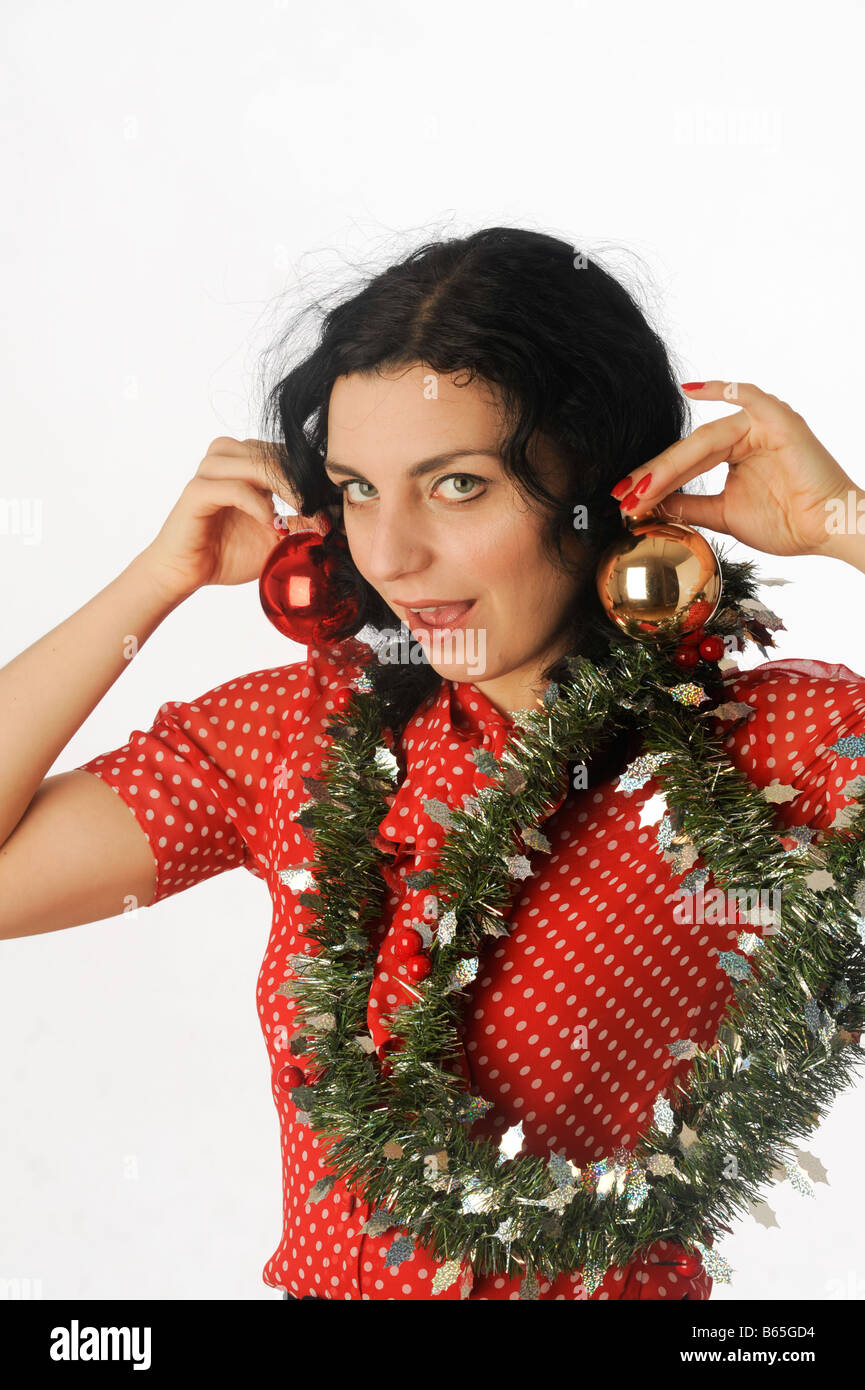 Woman with dark hair and red top wrapped in Christmas tinsel and ...