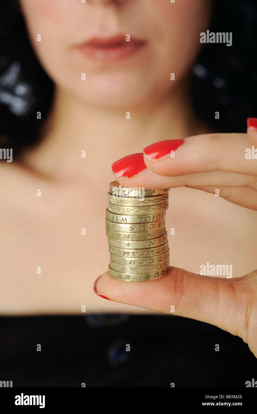 Stack of pound coins in a woman's hand with face in background Stock ...