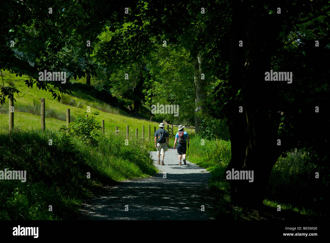 Two walkers on path around Grasmere lake, Lake District National Park ...