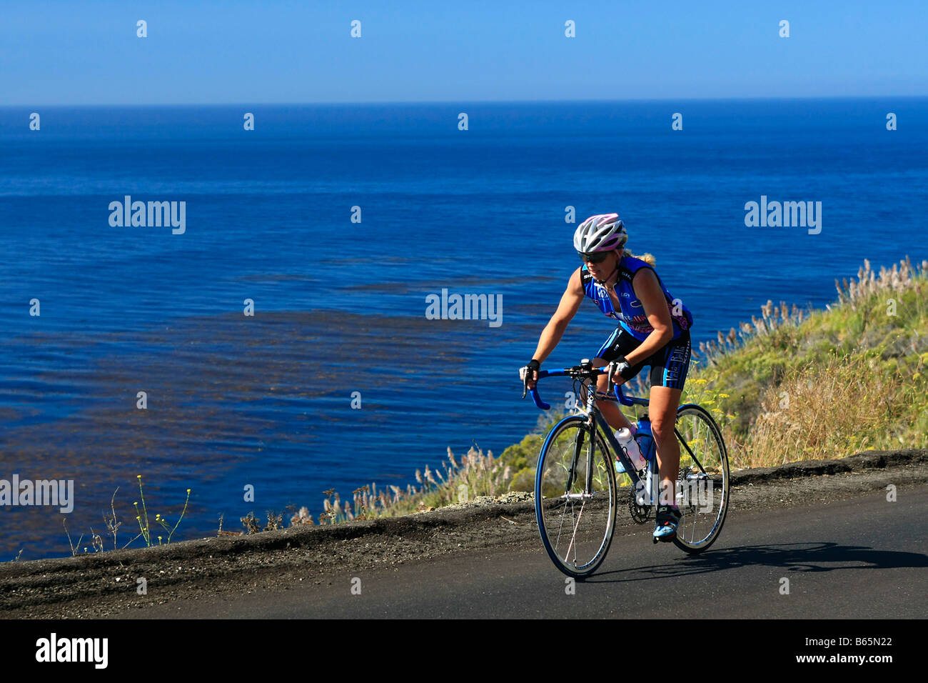 A female cyclist rides down the Big Sur Coast of California Stock Photo ...