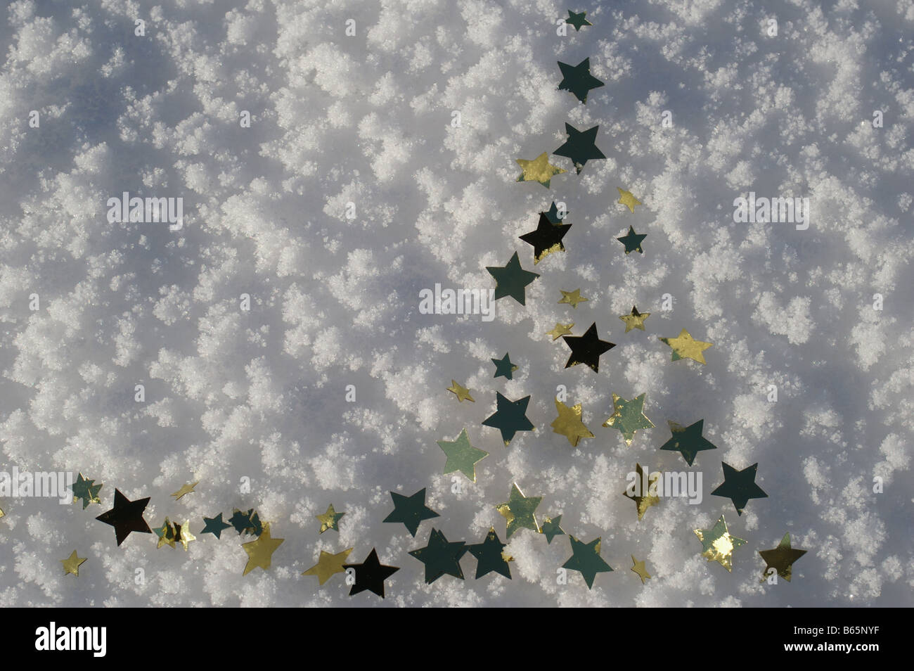 golden snow stars on a real snowy icy surface Stock Photo - Alamy