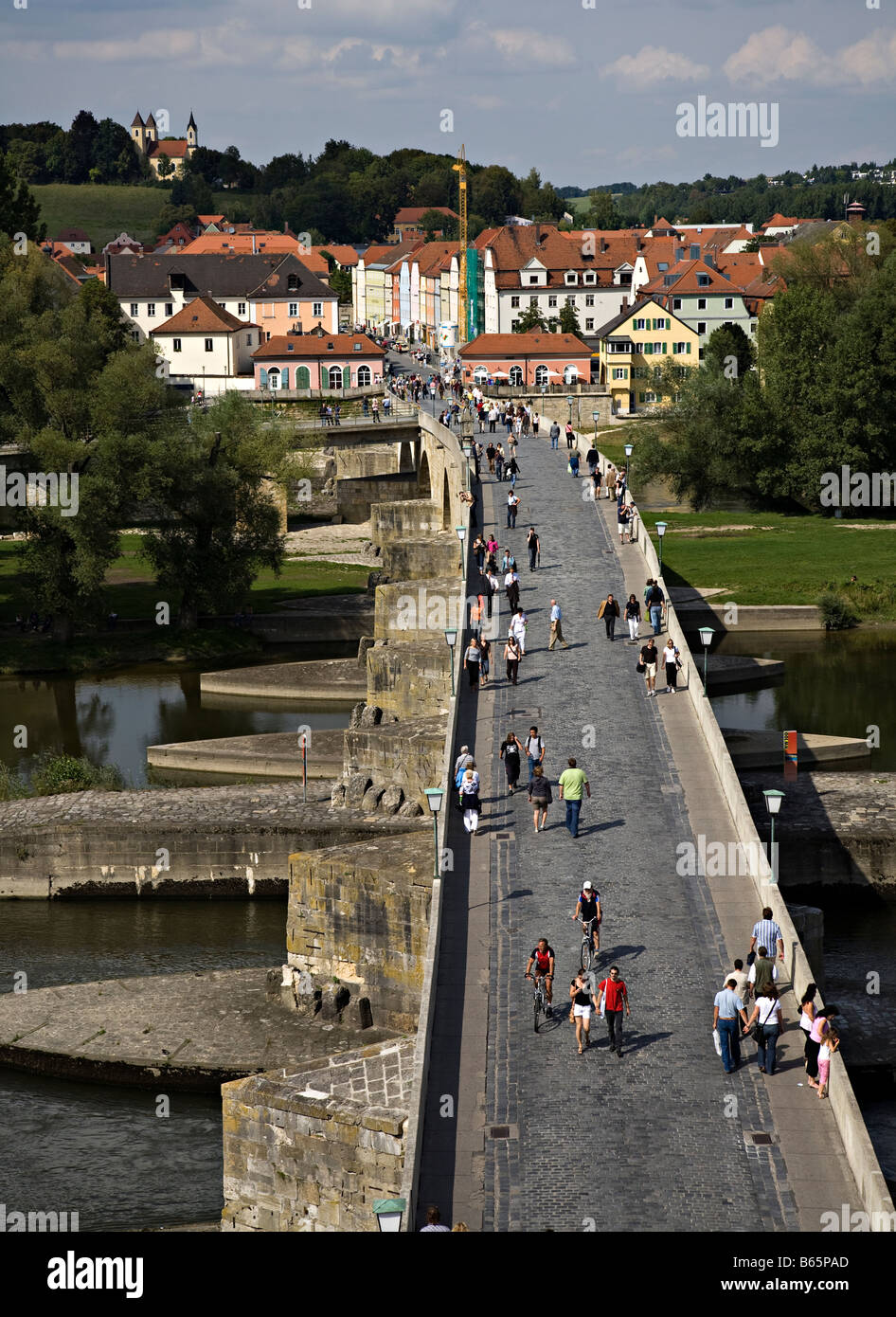 People walking across the old stone bridge built in the Middle Ages ...