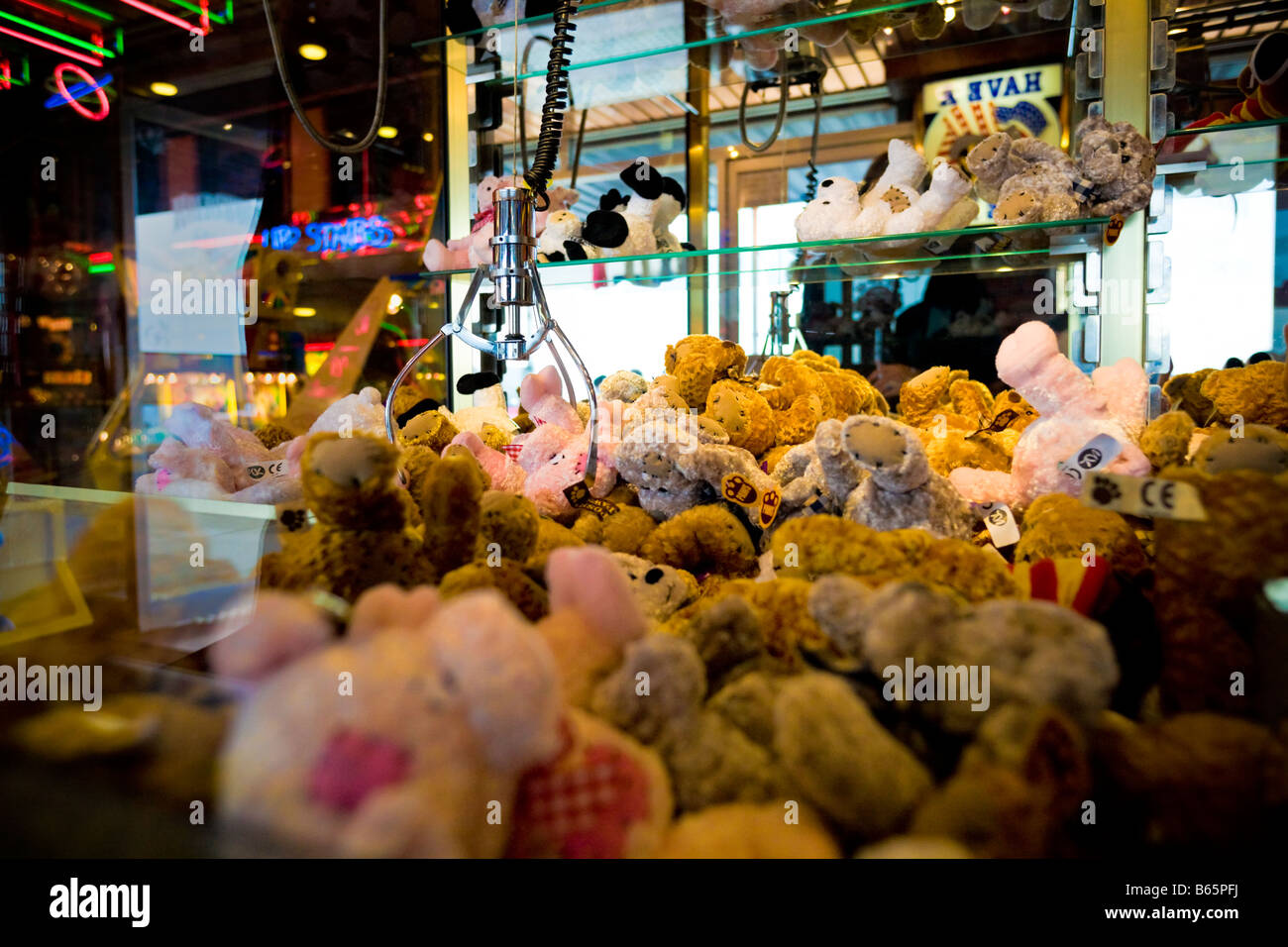 Amusement arcade game with crane grabbing a cuddly toy UK Stock Photo ...