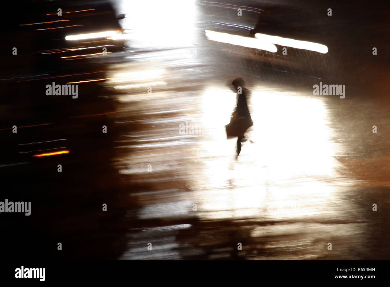 person walking in heavy rain at night in town Stock Photo - Alamy