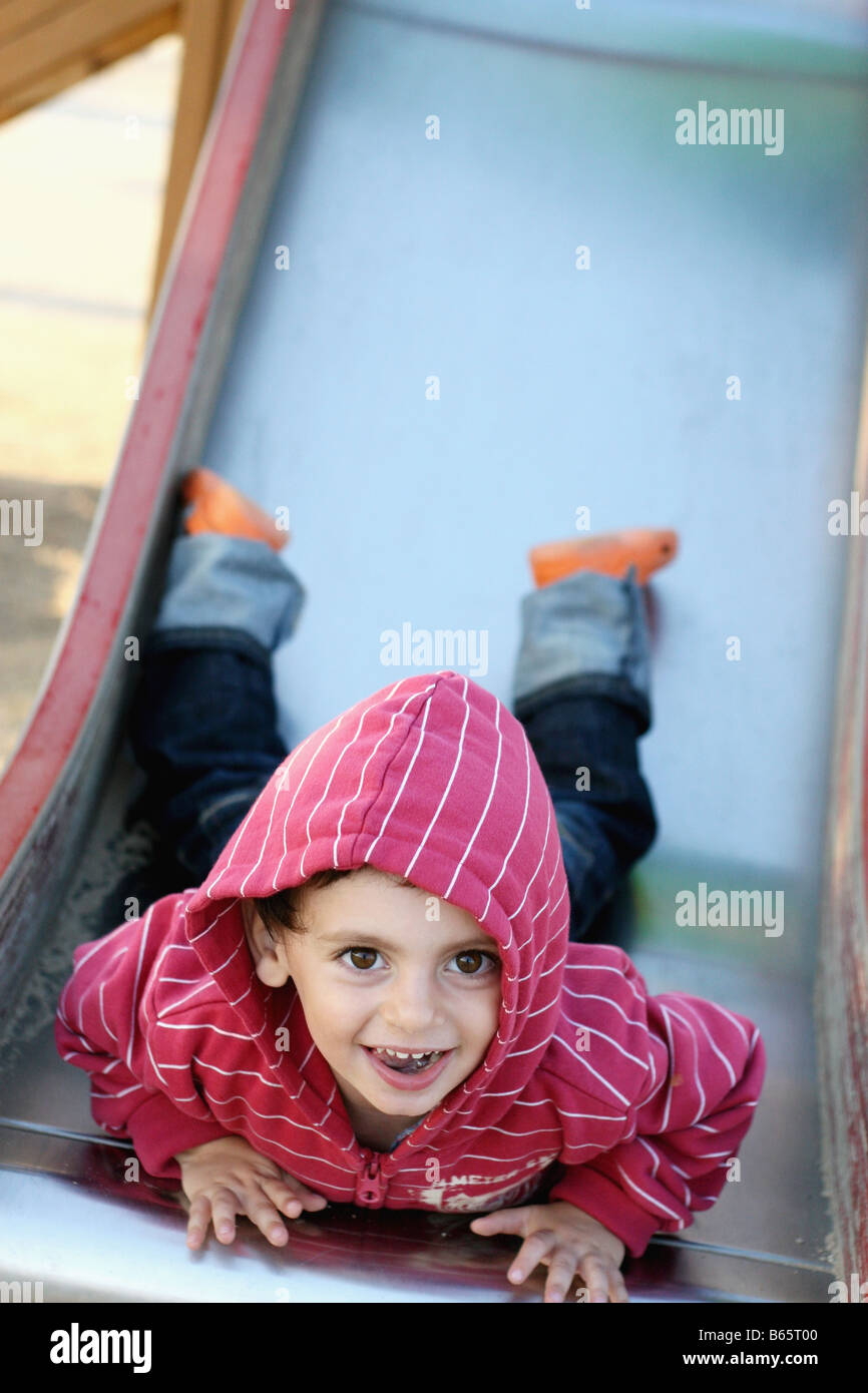 Happy boy sliding down the slide Stock Photo - Alamy