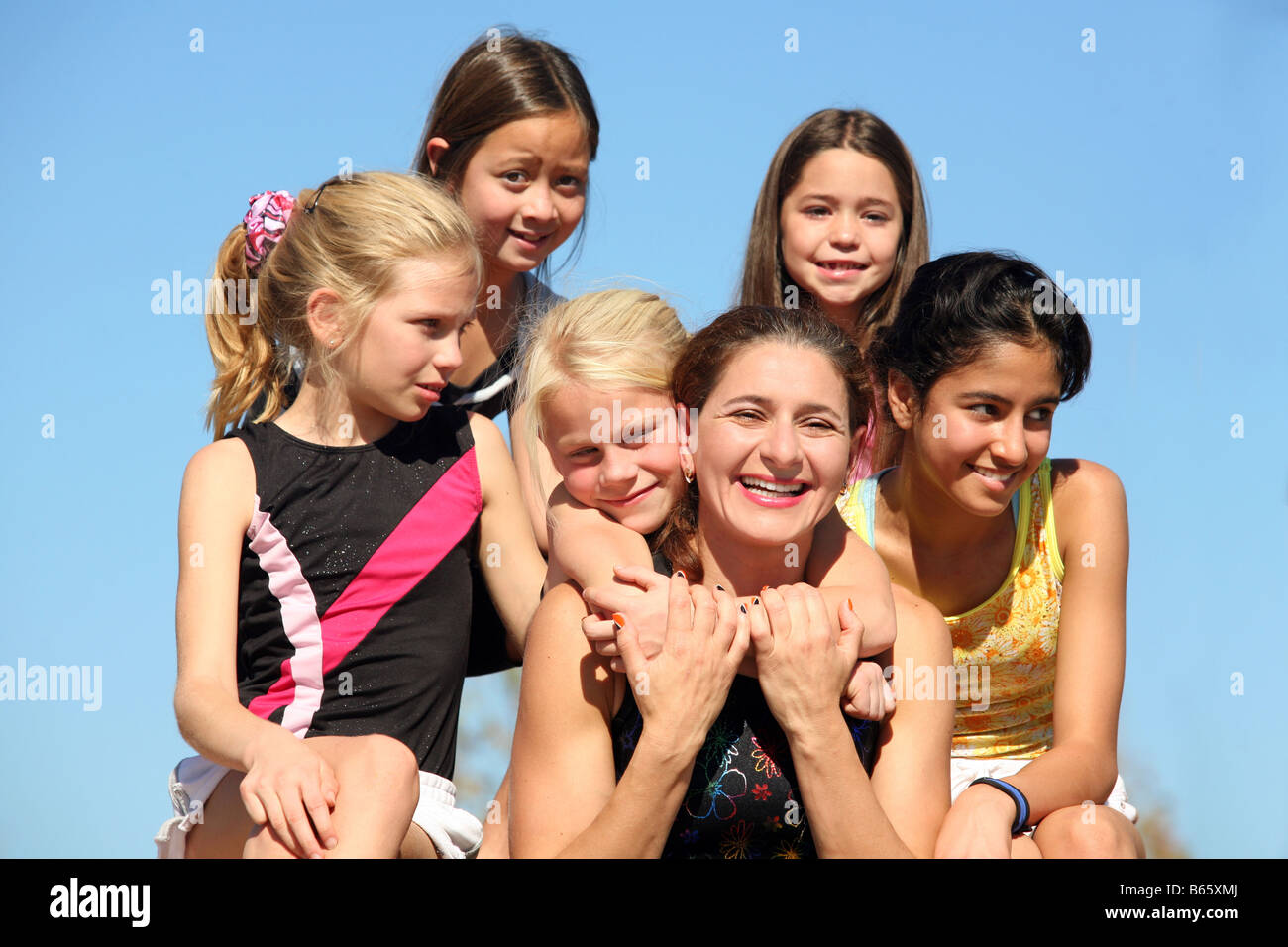 Woman laughing and five girls around her Stock Photo - Alamy