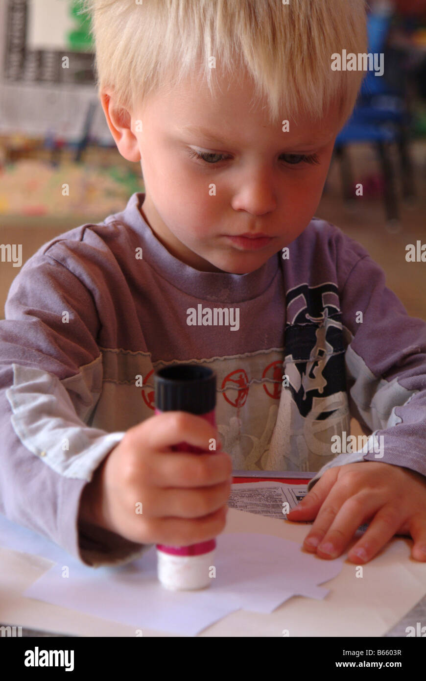 Little boy sticking shapes onto a picture at nursery Stock Photo - Alamy