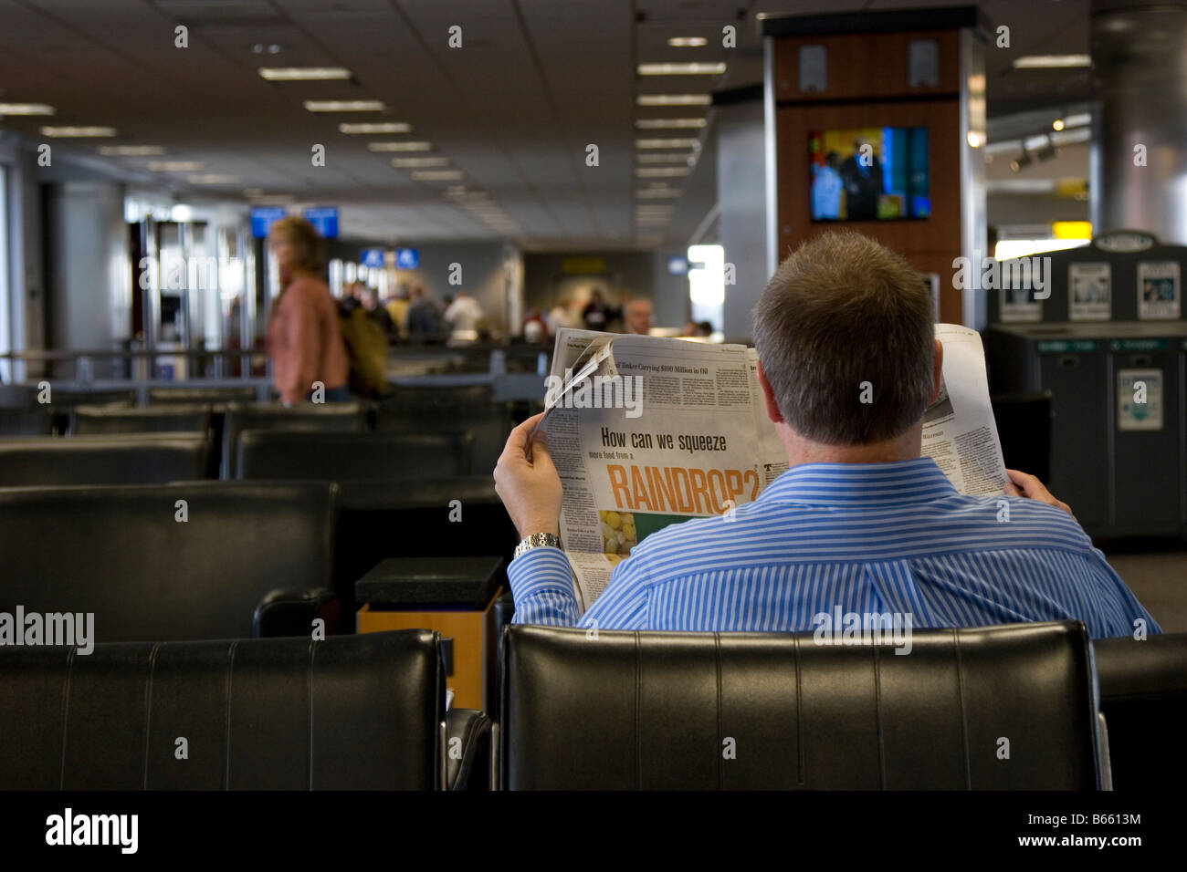 Man waiting for flight, reading newspaper in airport Stock Photo - Alamy