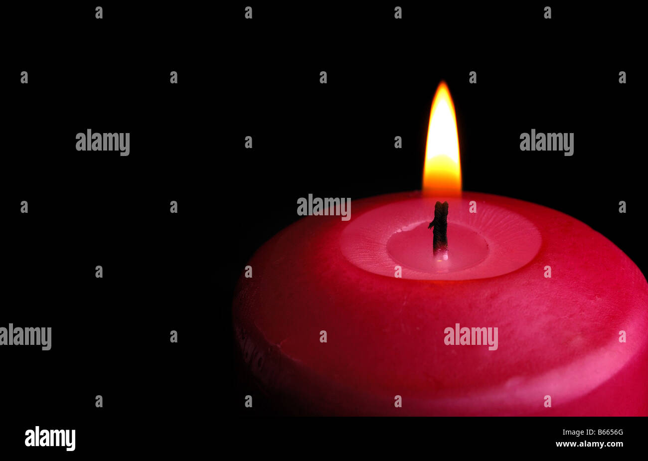 Candle A burning flame of a candle of red color Stock Photo - Alamy