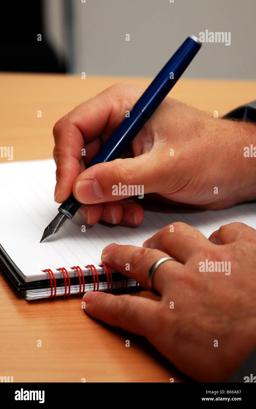 Mans hand writing in a notebook Stock Photo - Alamy