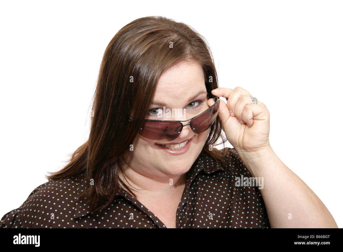 Beautiful plus sized model flirting by lowering her sunglasses to check ...