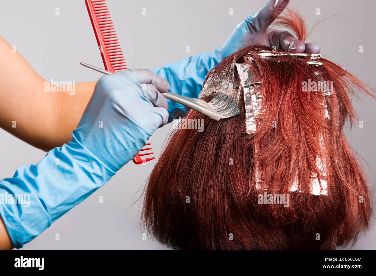 Hairdresser applying colour to customer's hair Stock Photo - Alamy