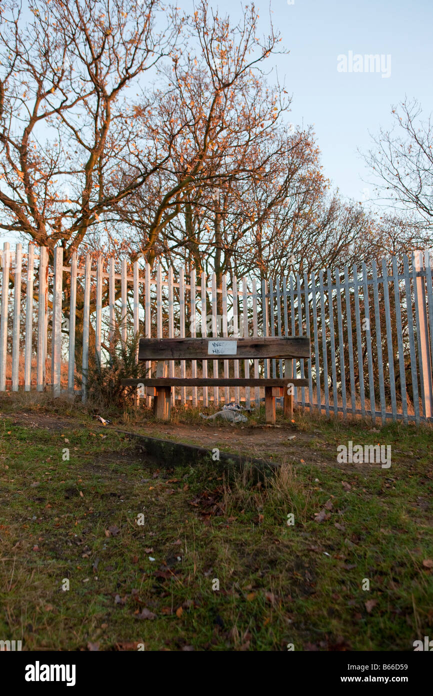 park bench backed by security fence Stock Photo - Alamy