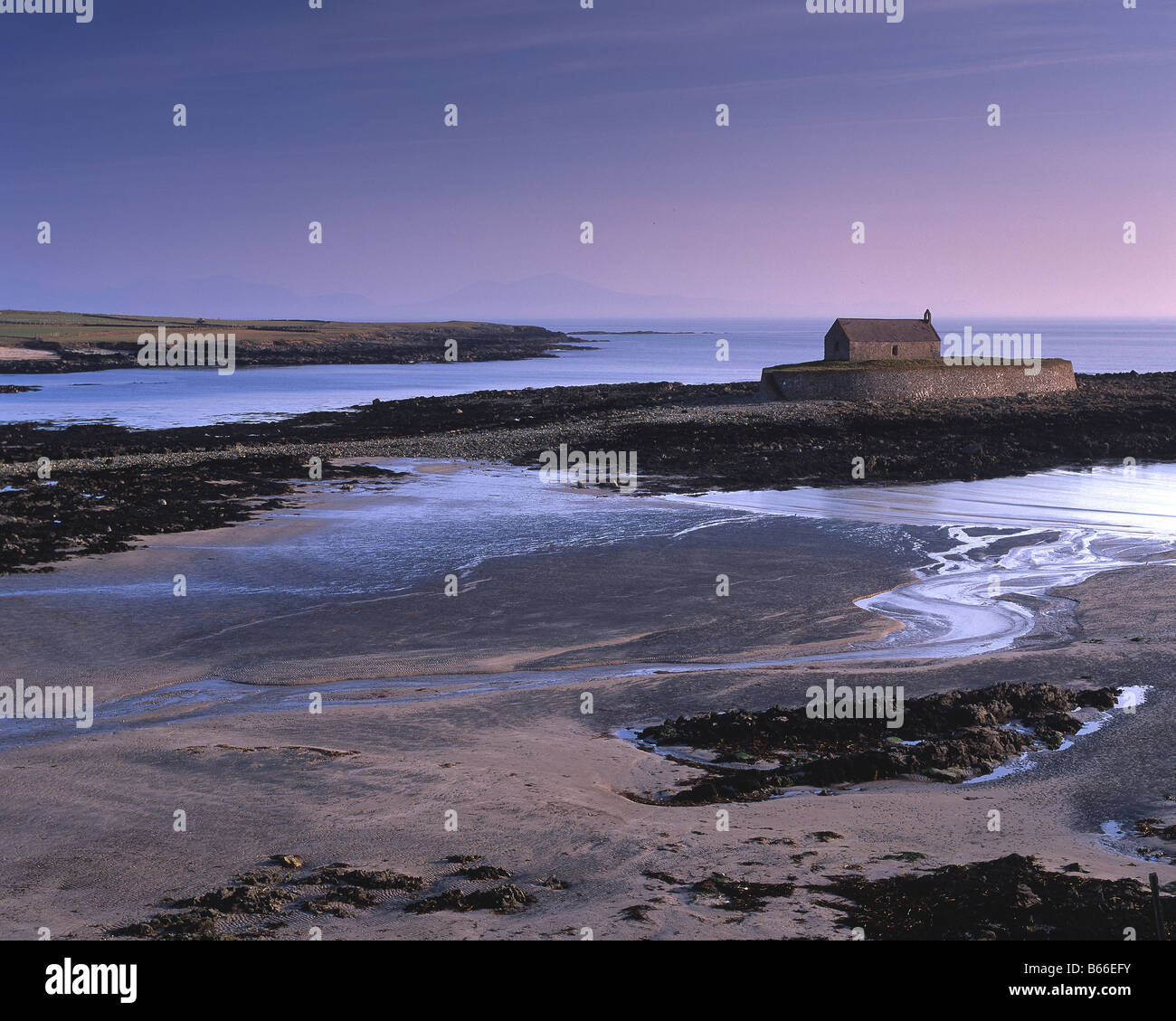 Dusk at Aberffraw Anglesey with St Cwyfan's church on the tiny tidal ...