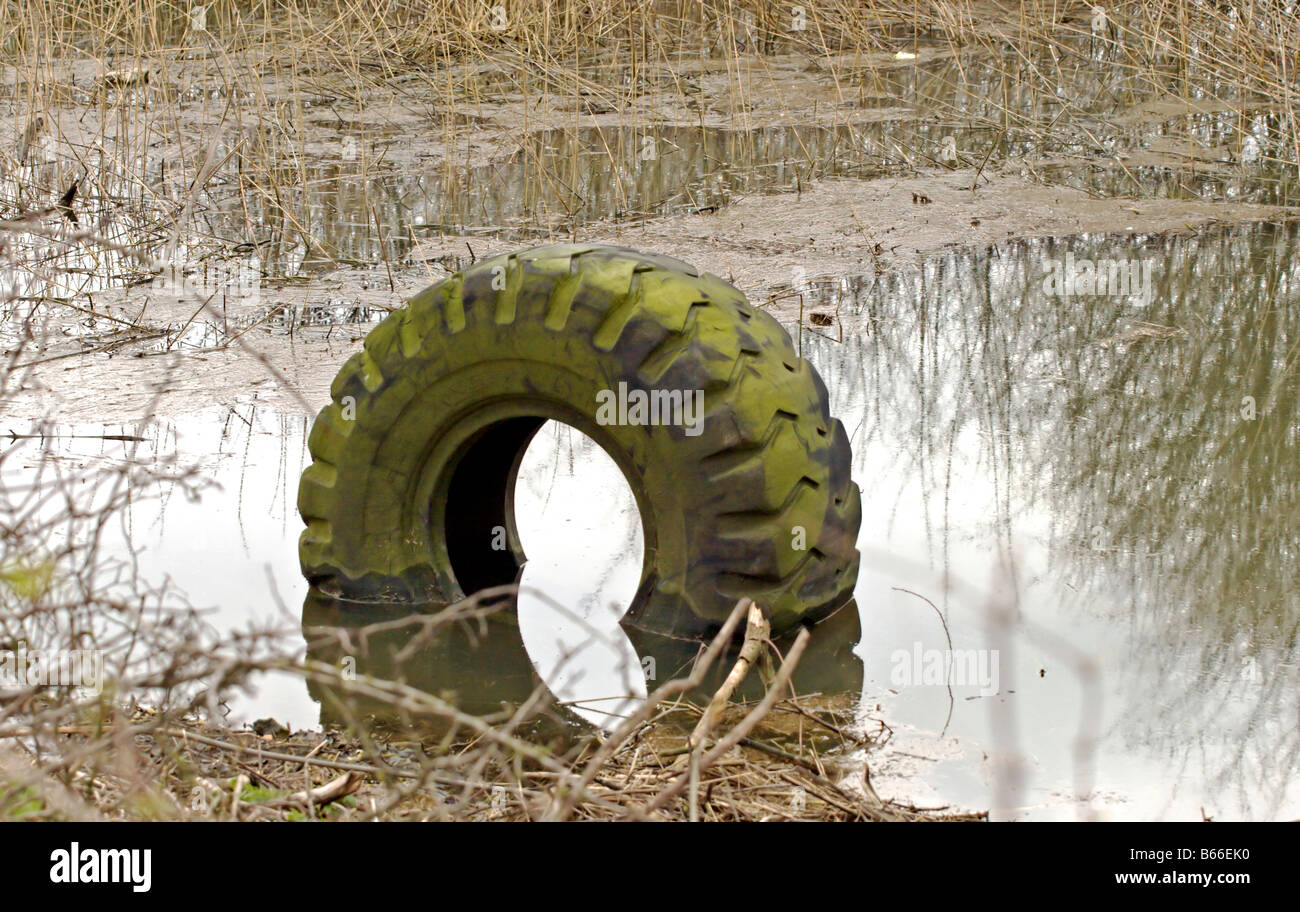 Discarded tractor tyre in pond in Cambridge Cambridgeshire UK Stock ...