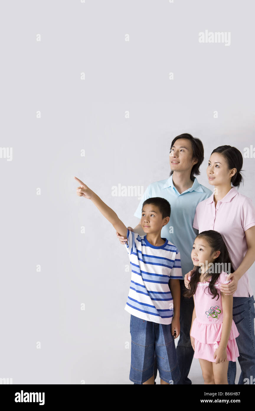 Young family with two children looking away and standing together Stock ...
