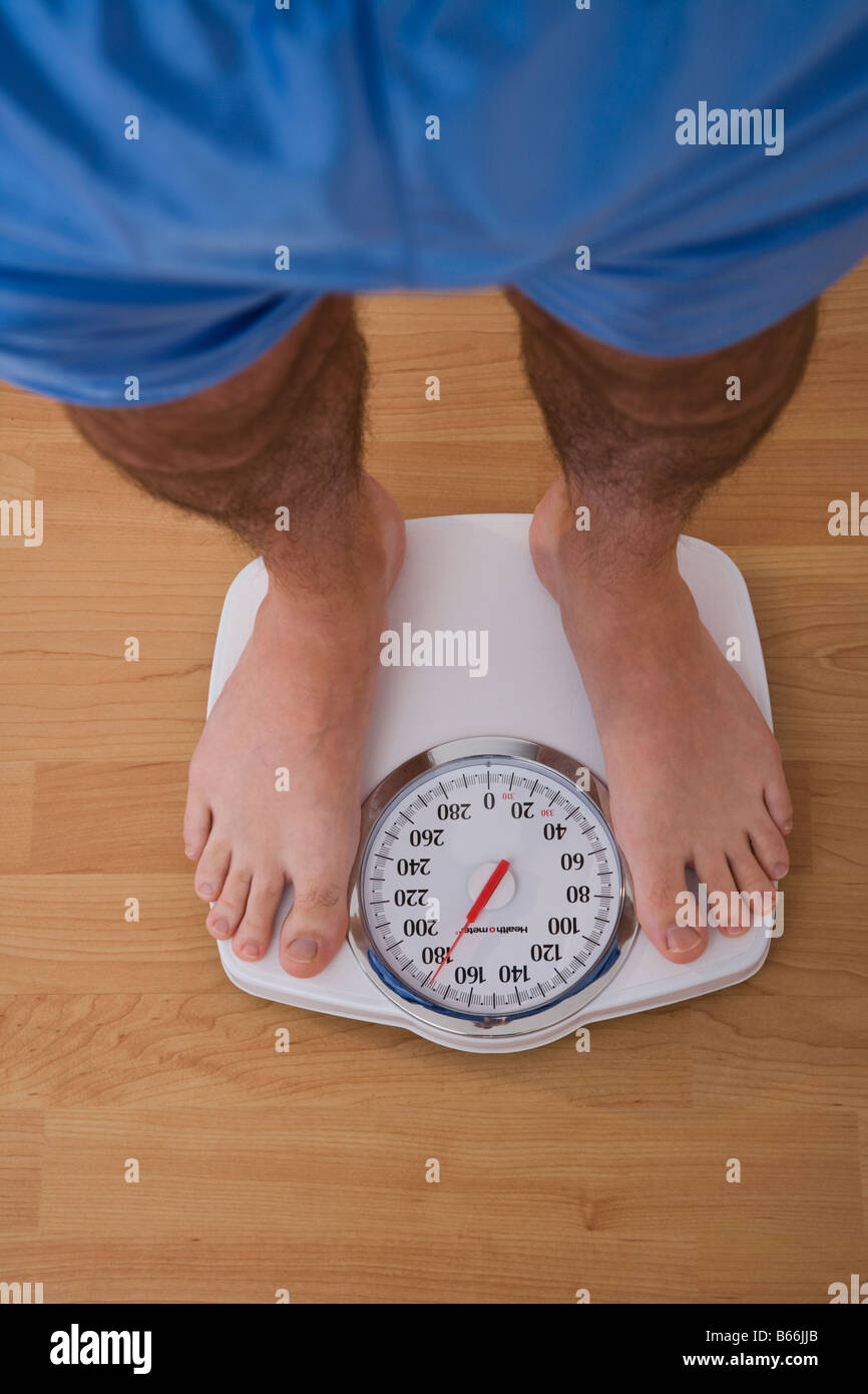 Man standing on bathroom scales, low section Stock Photo - Alamy