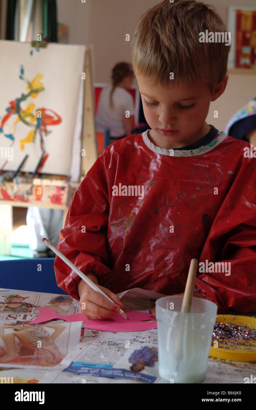 Boy making a picture with glitter doing art at nursery Stock Photo - Alamy
