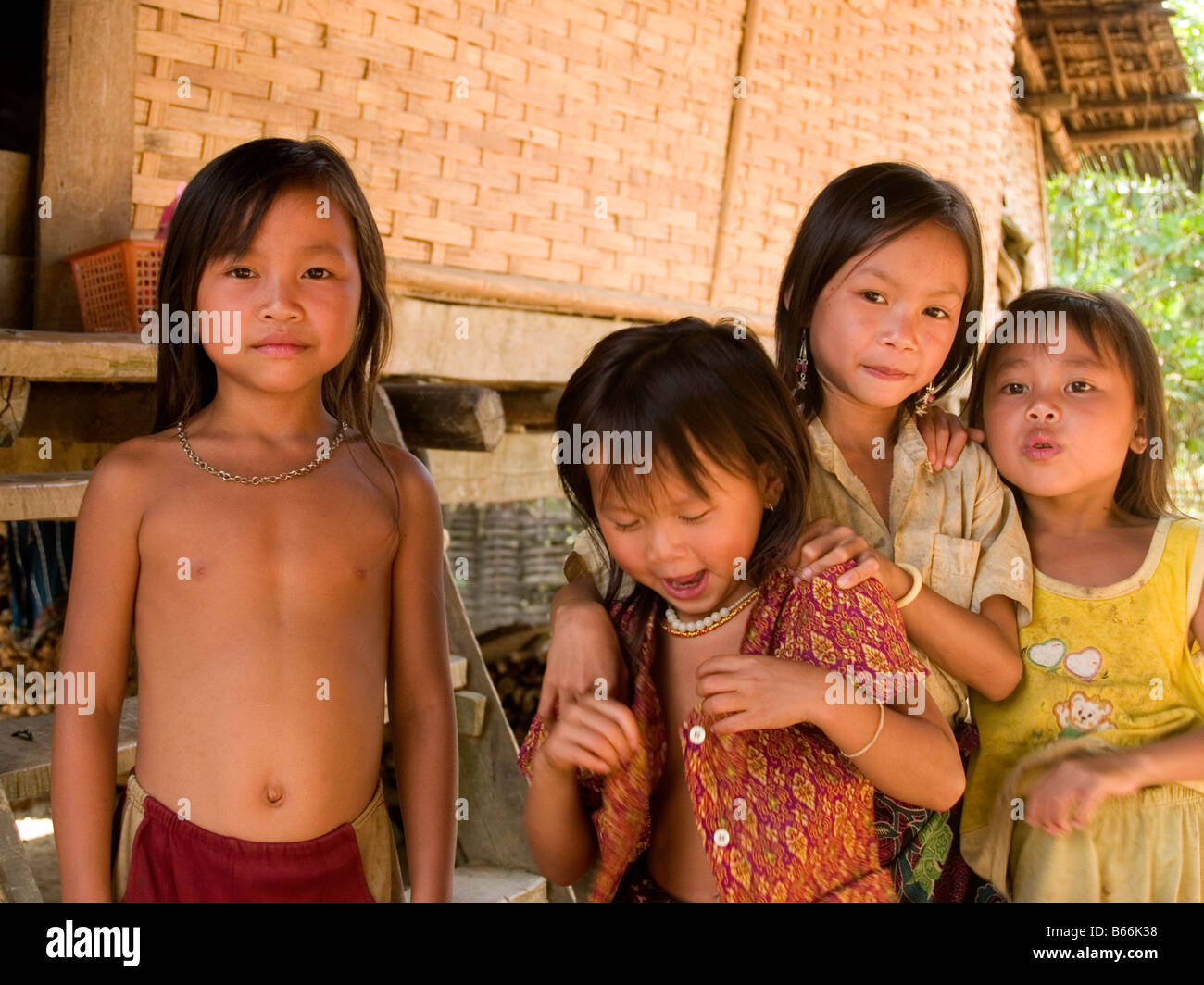 Lao girls in front of their home in Muang Ngoi village in northern Laos Stock Photo - Alamy