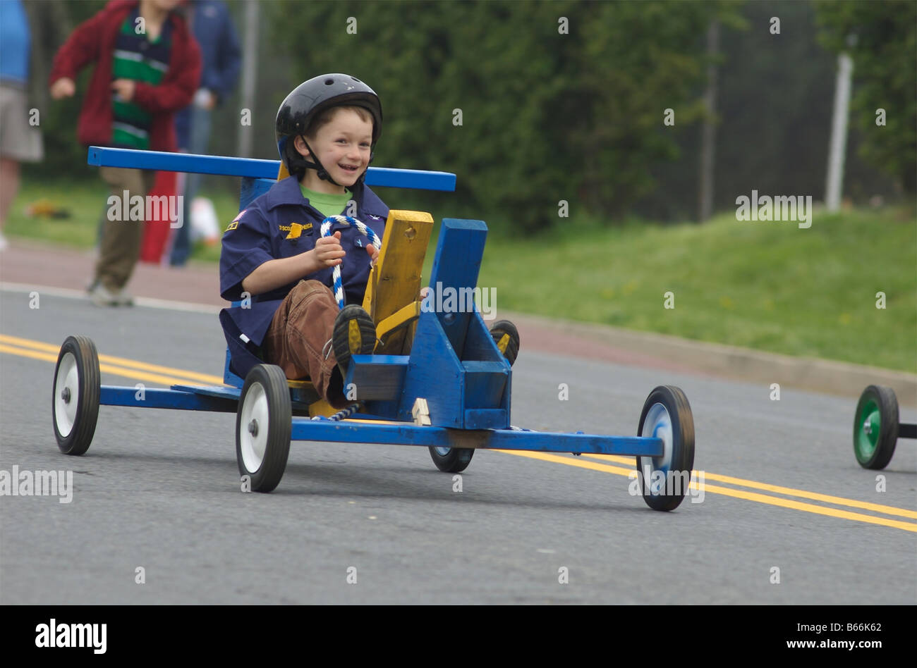Seven year old cubscout smiling as he races a Cubmobile cart downhill ...