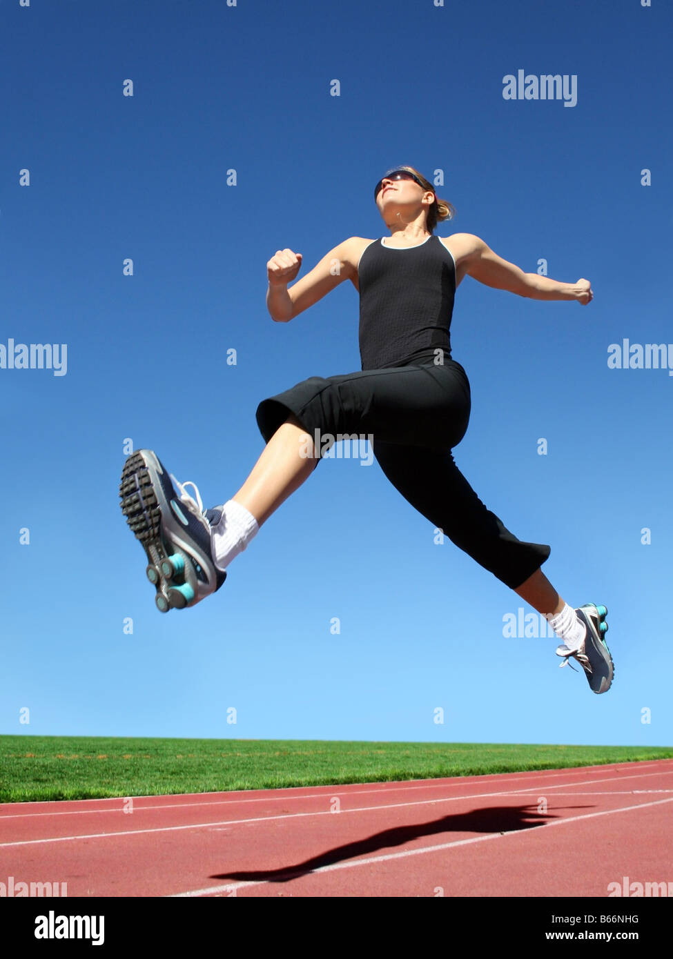 Young woman running on a racetrack Stock Photo - Alamy