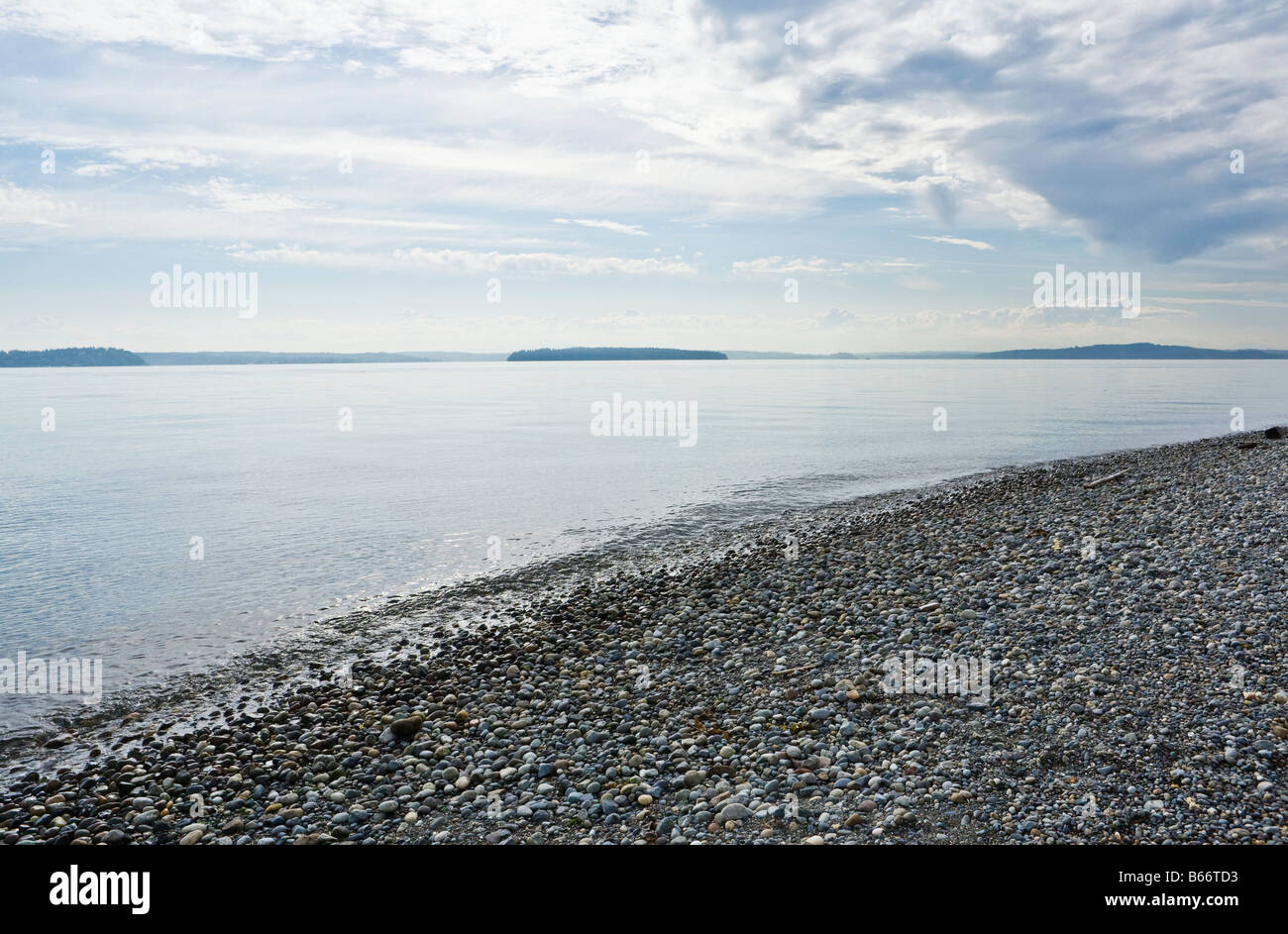 The shore of Lincoln Park in Seattle WA looking over the Puget Sound to ...