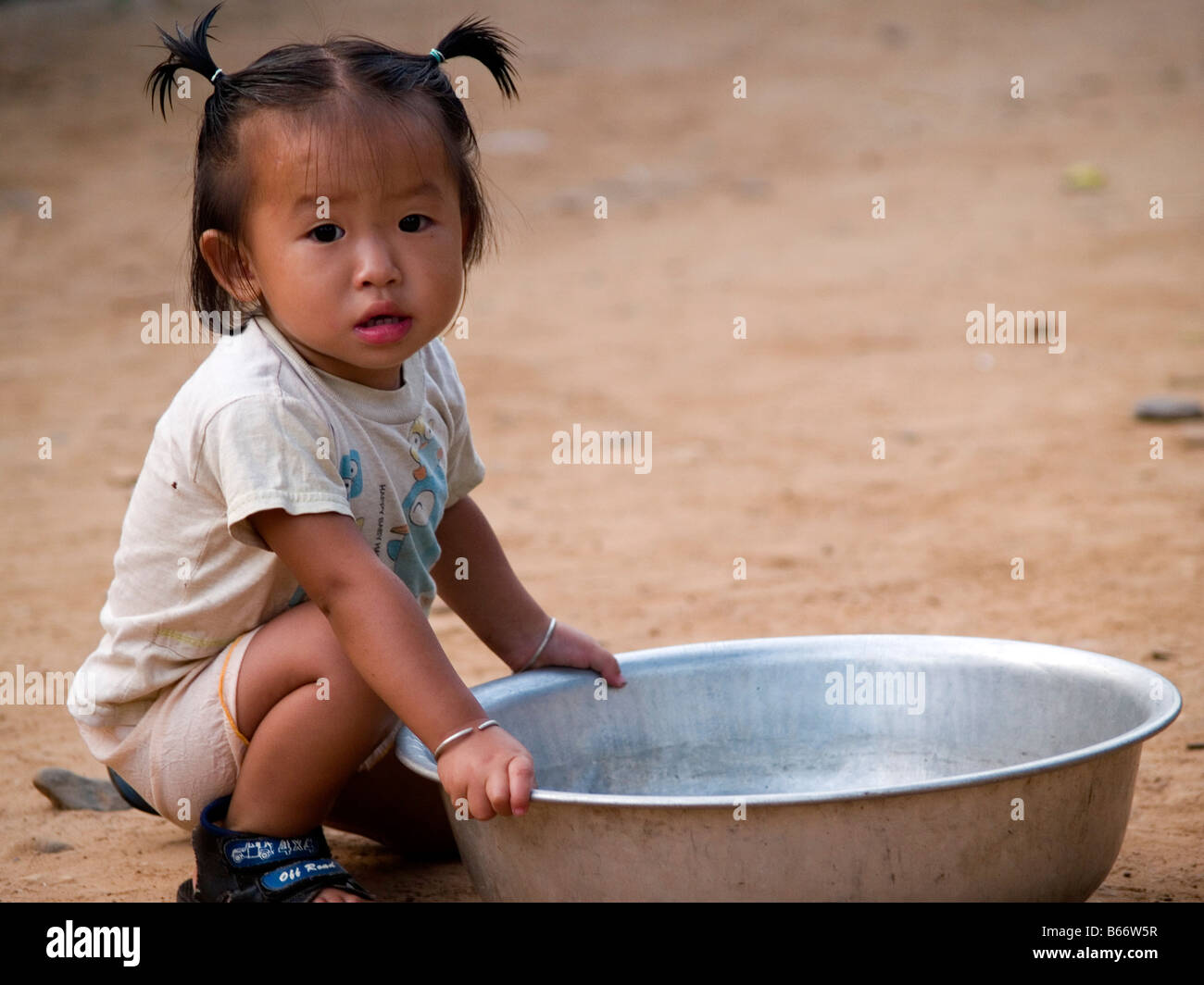 cute little girl and her basin in Muang Ngoi village in northern Laos ...