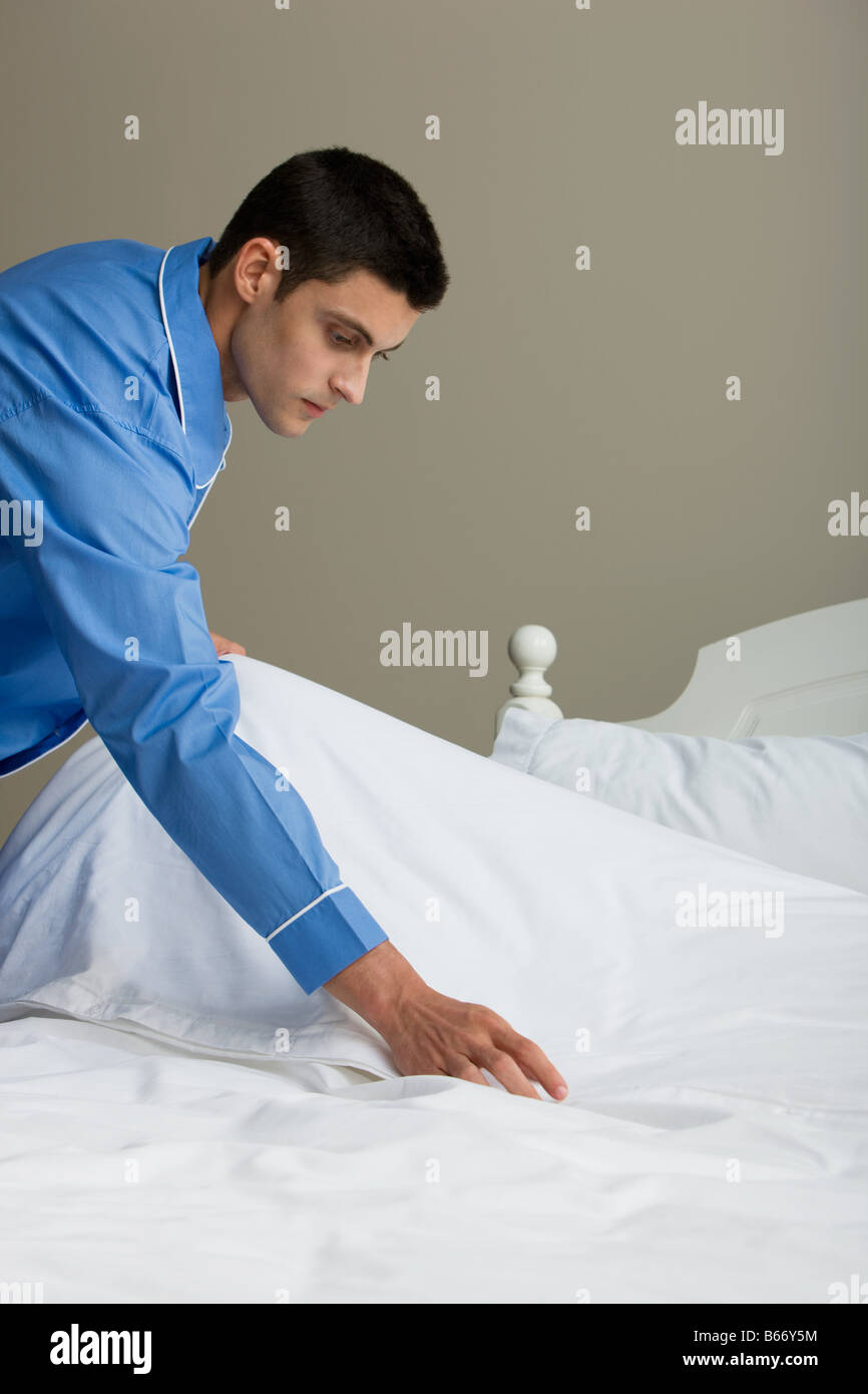 A man tidying the bed Stock Photo - Alamy