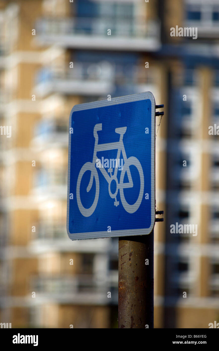 blue and white cycle path sign againt a background of highrise ...