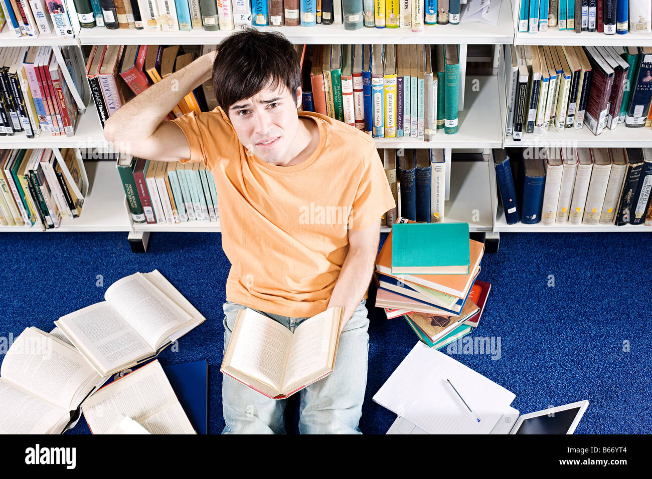 Confused young man book scratching head hi-res stock photography and ...