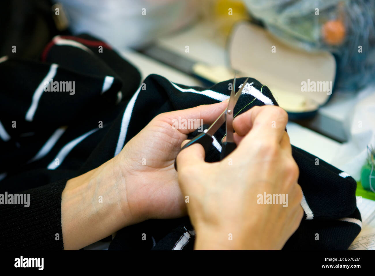 Tailor making repairs to some clothes Stock Photo - Alamy