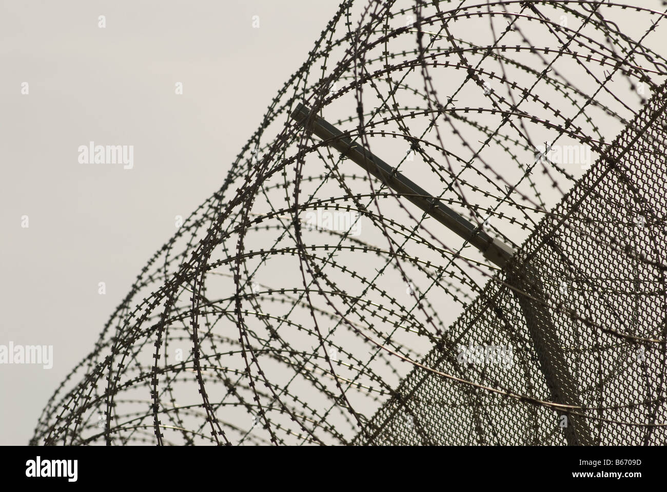 Razor wire and barbed wire on a private prison fence Stock Photo - Alamy