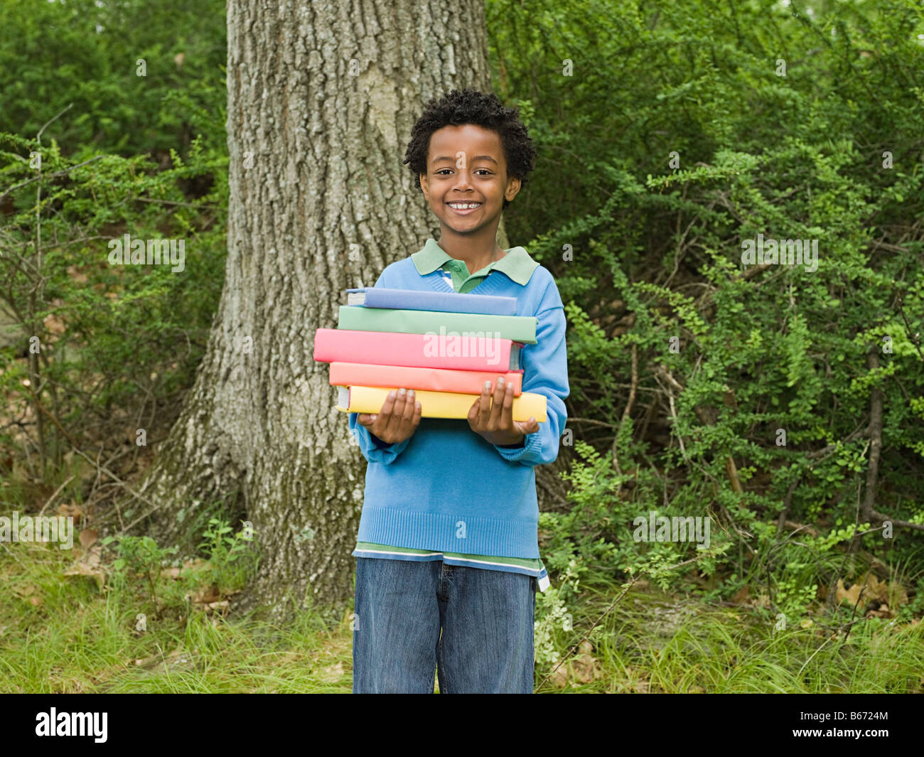 Portrait of a boy holding a stack of books Stock Photo - Alamy
